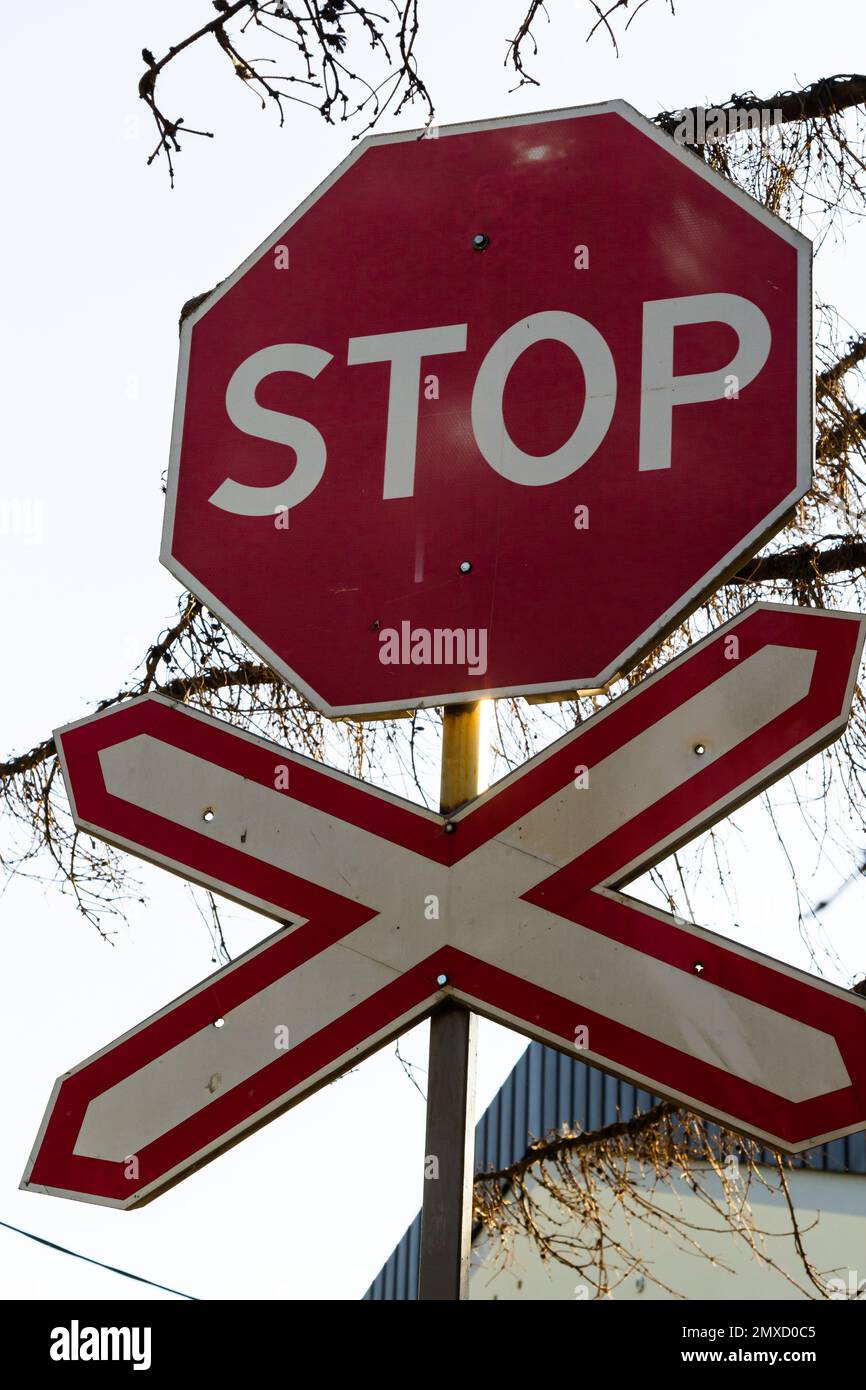 Traffic sign stop at the intersection with railway tracks in cloudy ...