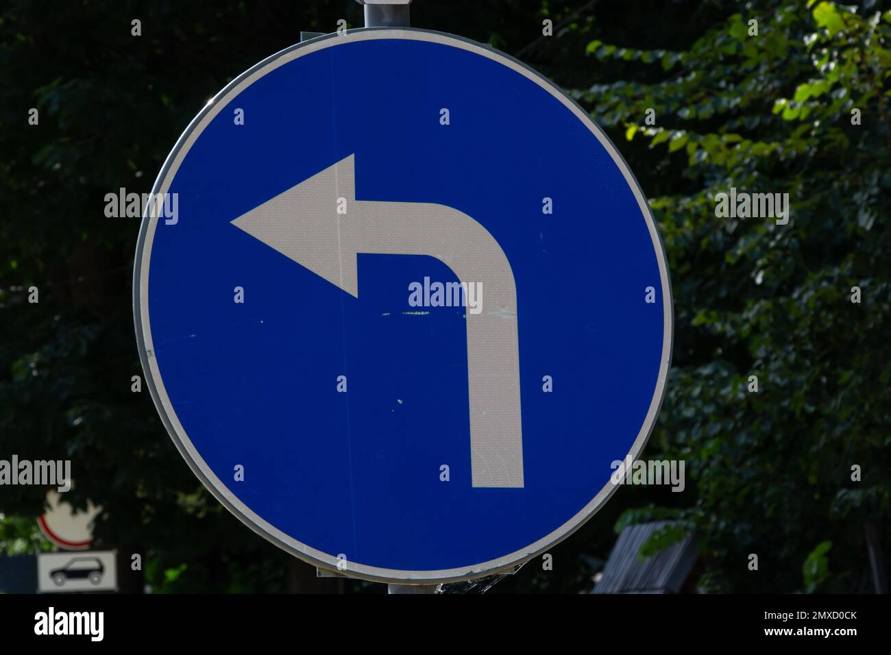 traffic signs, turn left signs with blurred background of trees and sparkling sunlight Stock ...