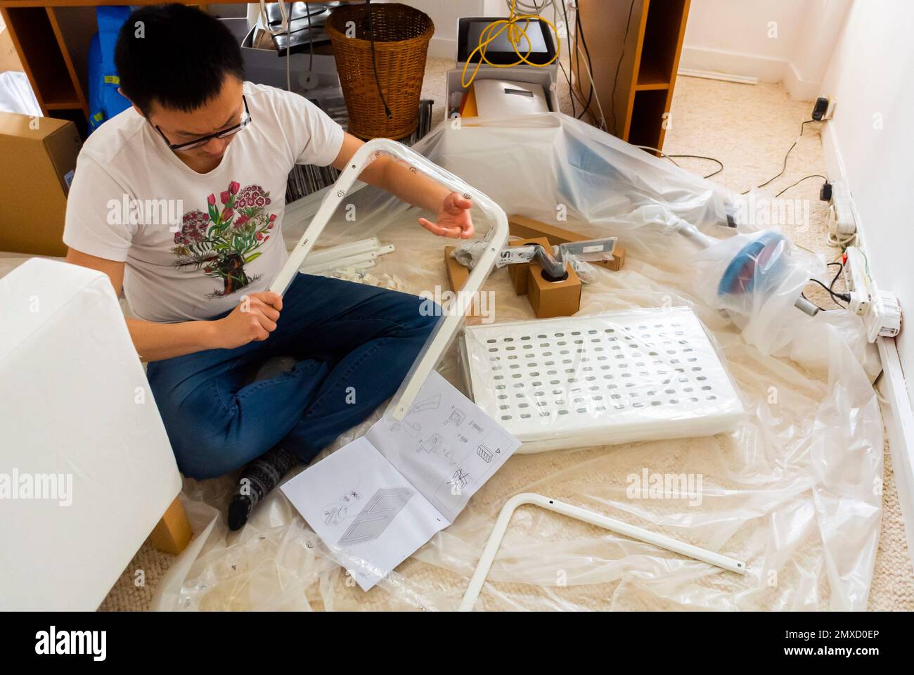 Paris, France, Chinese Male Assembling Furntiute at home from IKEA ...
