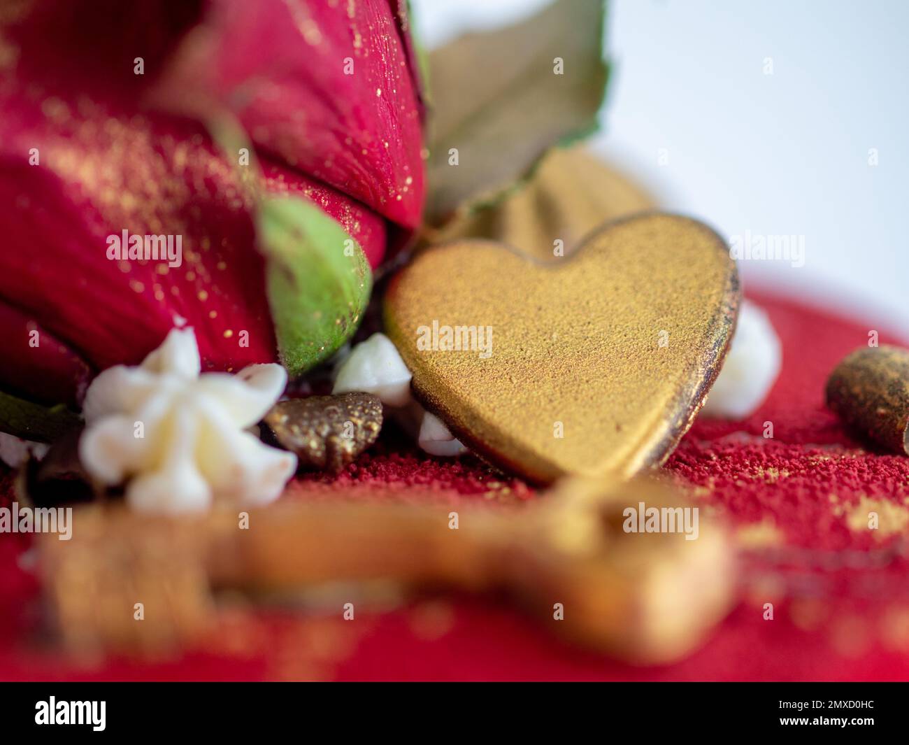 frosted red velvet cake with flower and heart toppers and golden paint ...