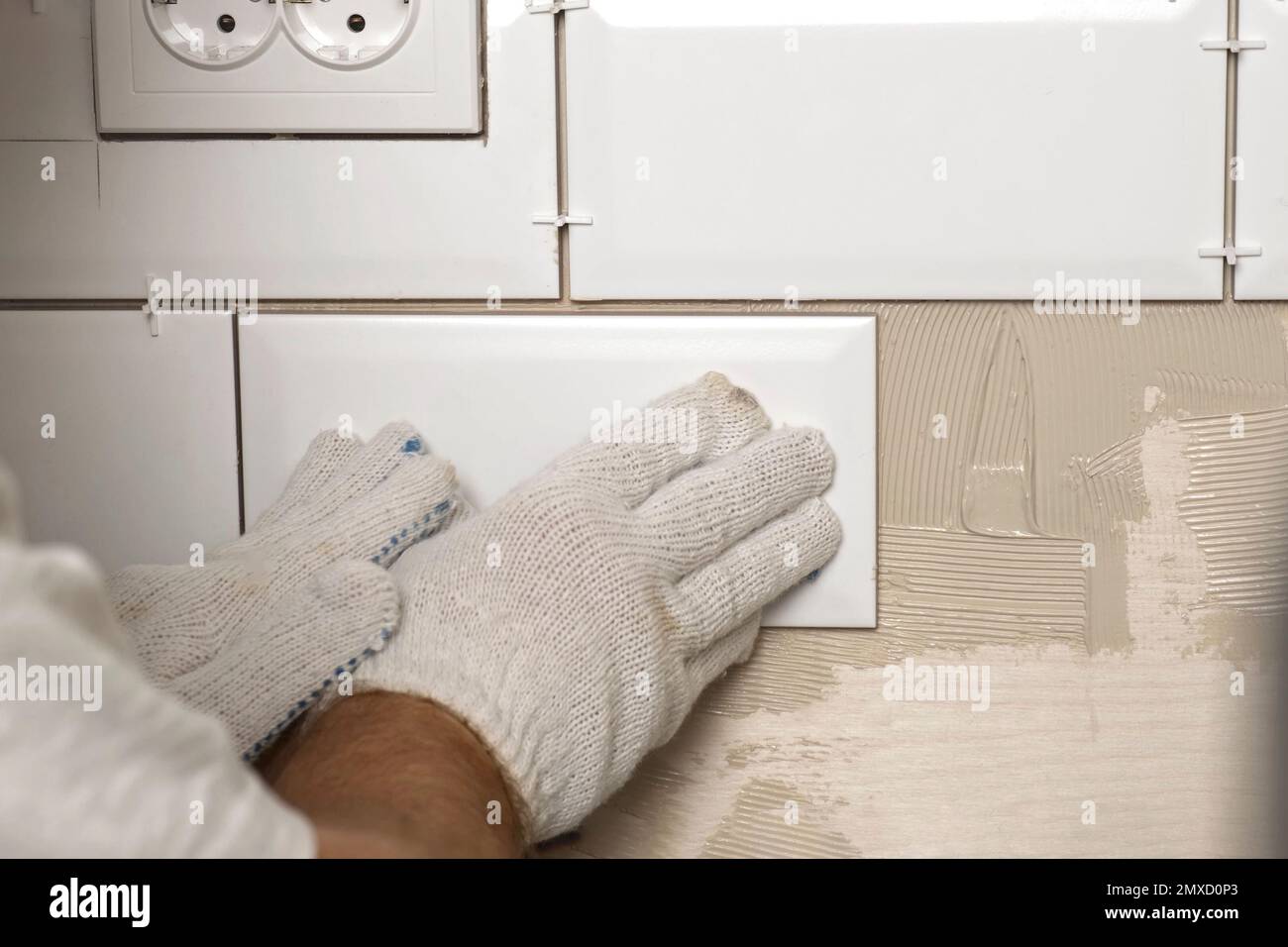 Male Worker Master Laying Ceramic Tiles on the Wall of Kitchen ...