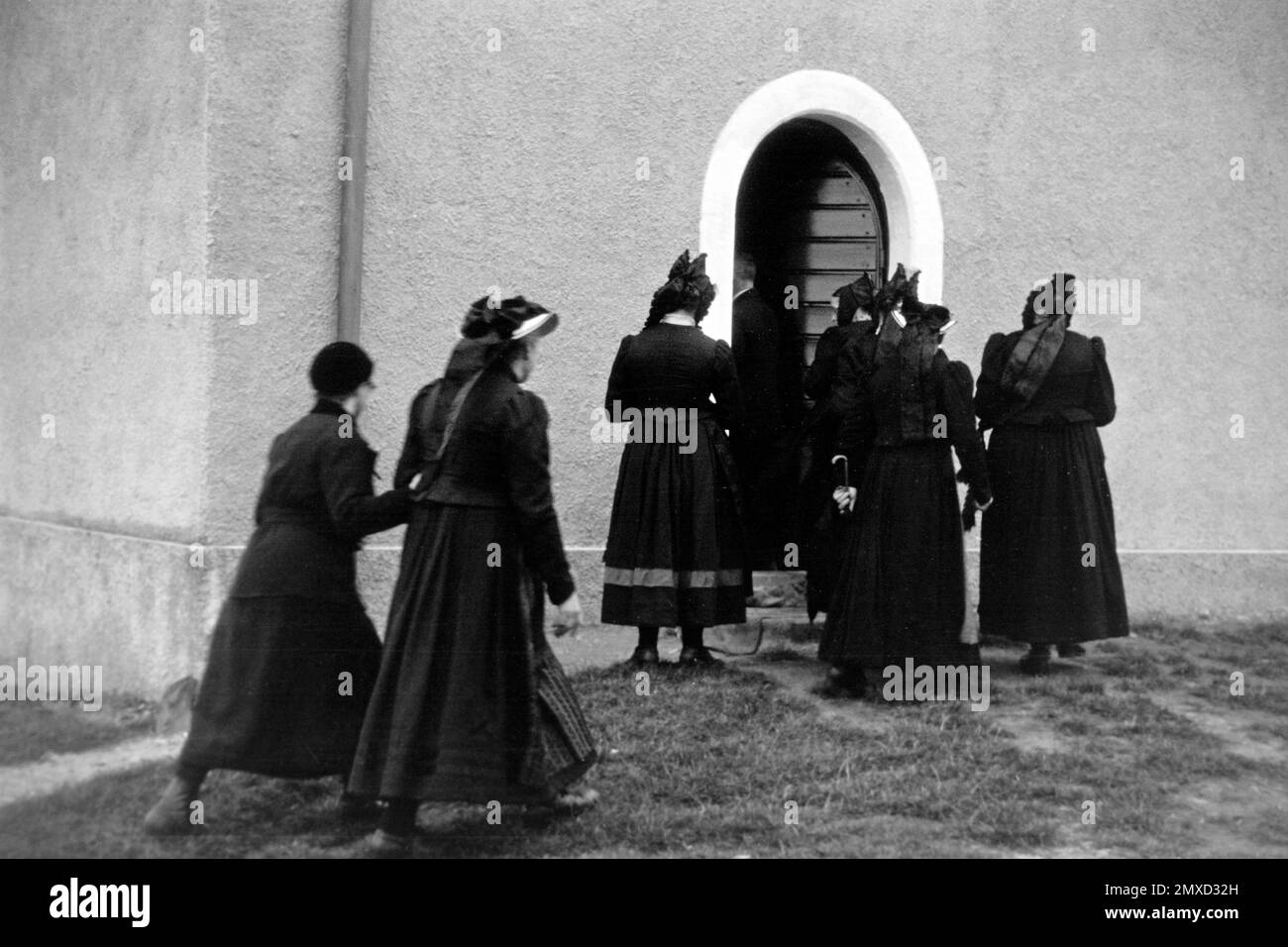 Frauen im Festtagsgewand betreten eine Kirche, Schwarzwald, 1938. Women ...