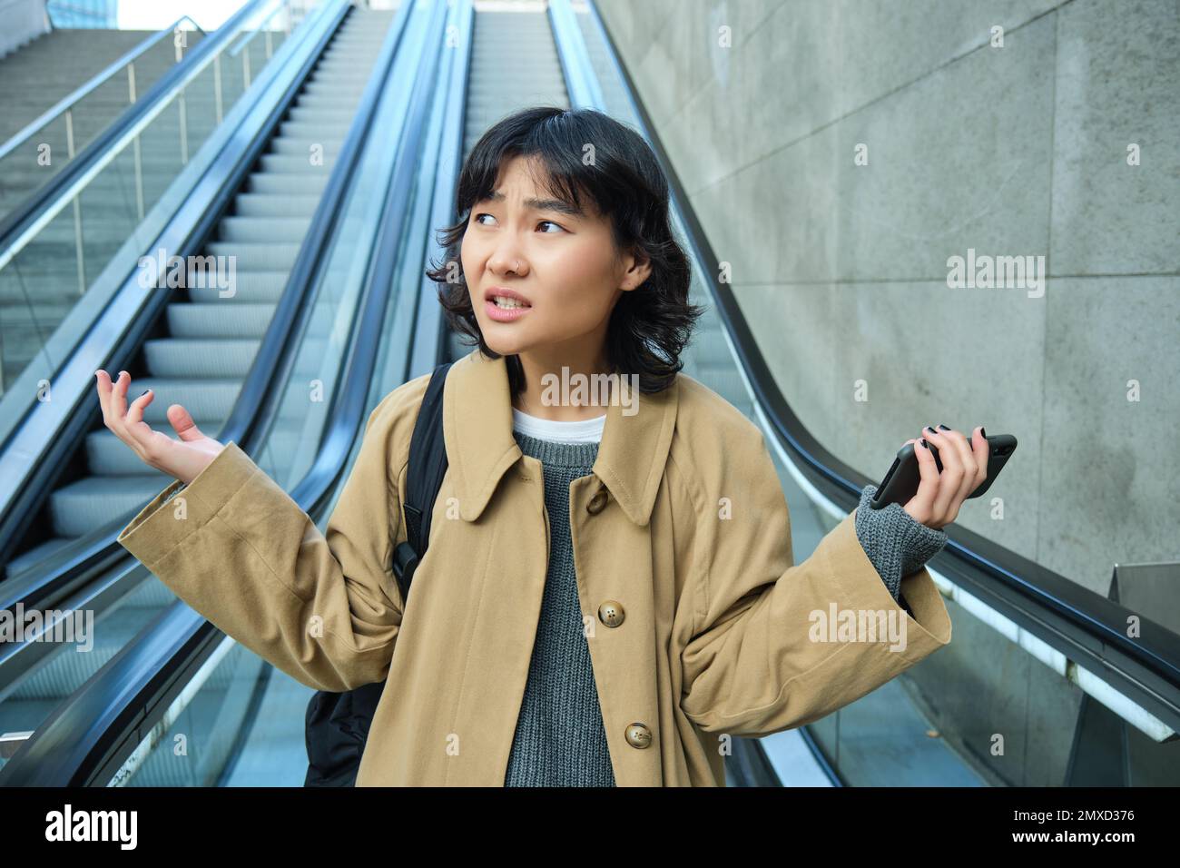 Portrait of confused asian girl doesn't know where she is, lost in ...