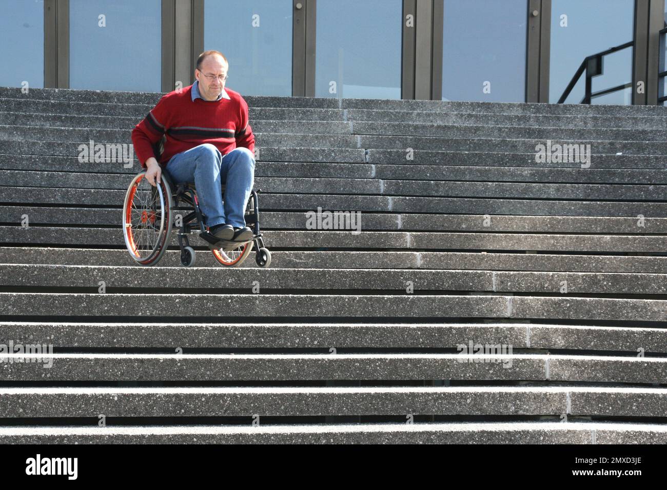 wheelchair user standing on a non-barrier-free outside staircase, front ...