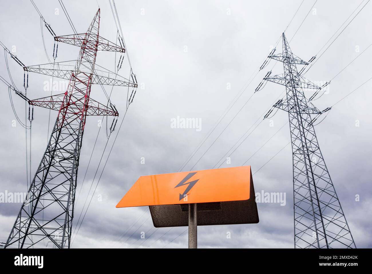 high-voltage transmission pole with power lines, sign 'Caution Heavy ...