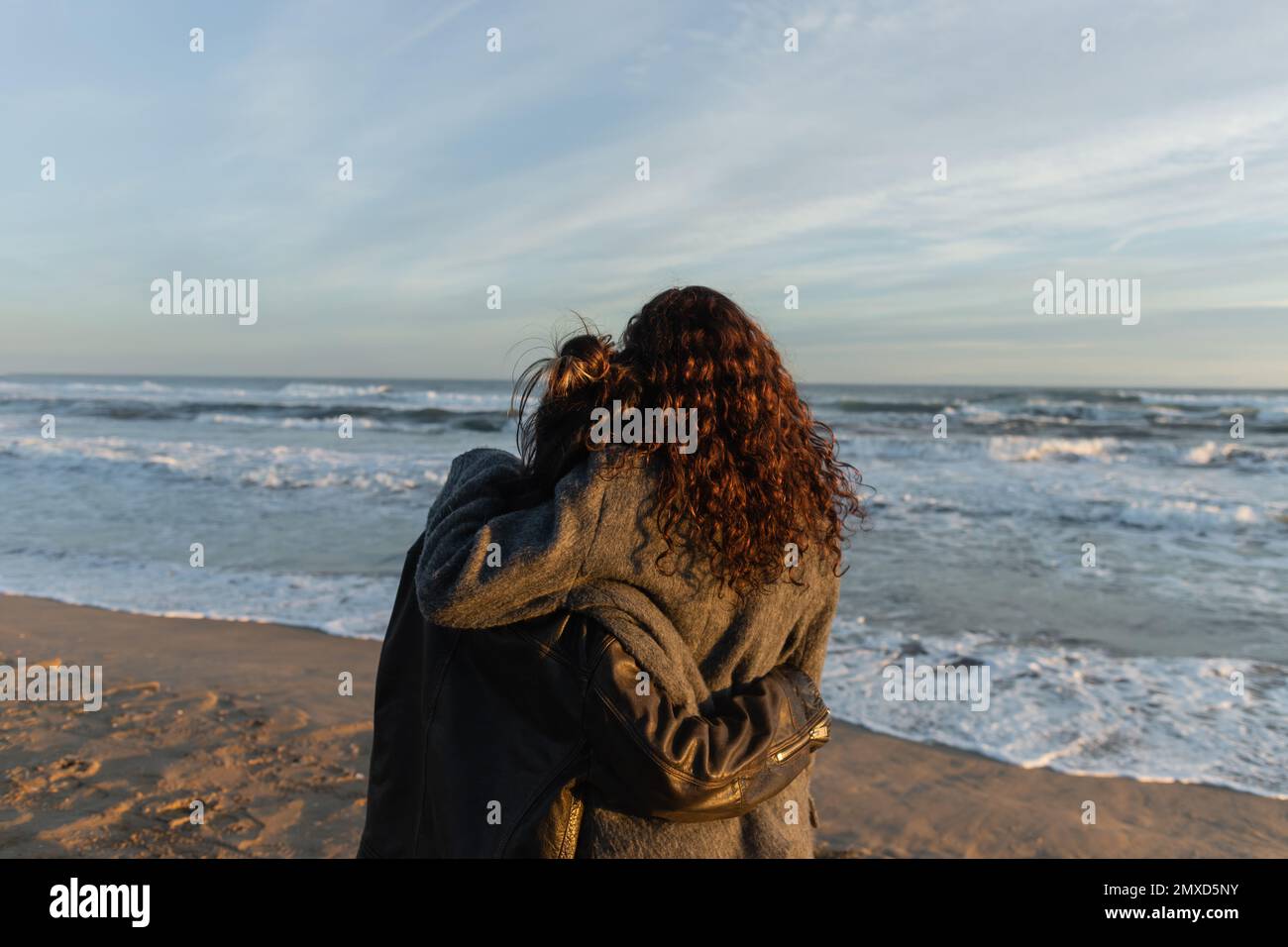 Back view of friends hugging on beach near sea in Spain Stock Photo - Alamy