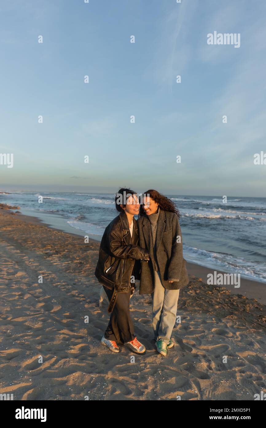 Cheerful friends walking on beach in Barcelona during sunset Stock ...