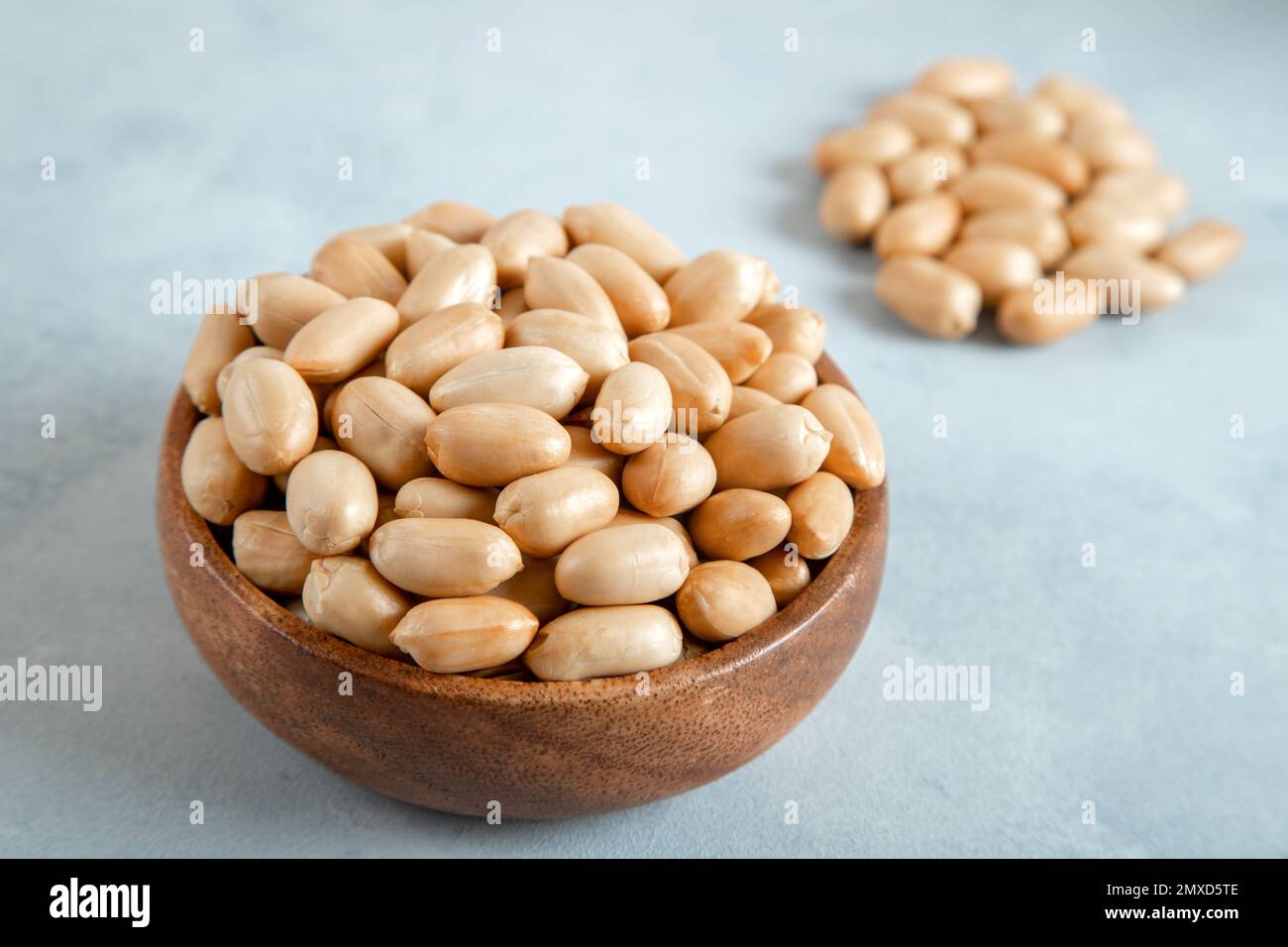 Bowl full of roasted peeled peanuts on bright background Stock Photo ...