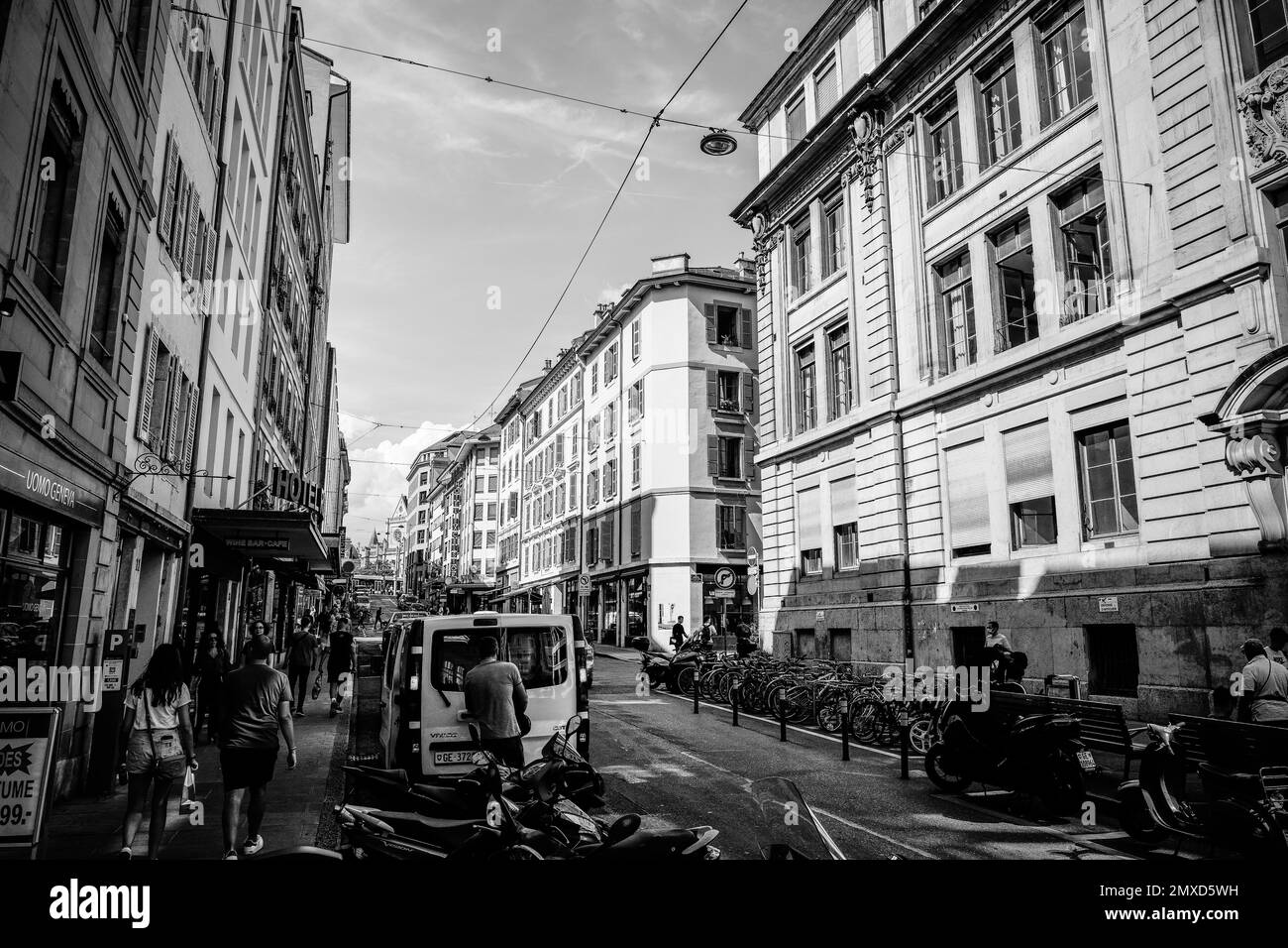 A grayscale shot of a street at the center of Geneva with buildings and ...