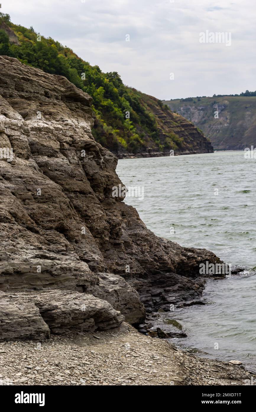 rocks on the shore of the lake, river. Surf on a rocky shore. Lake ...