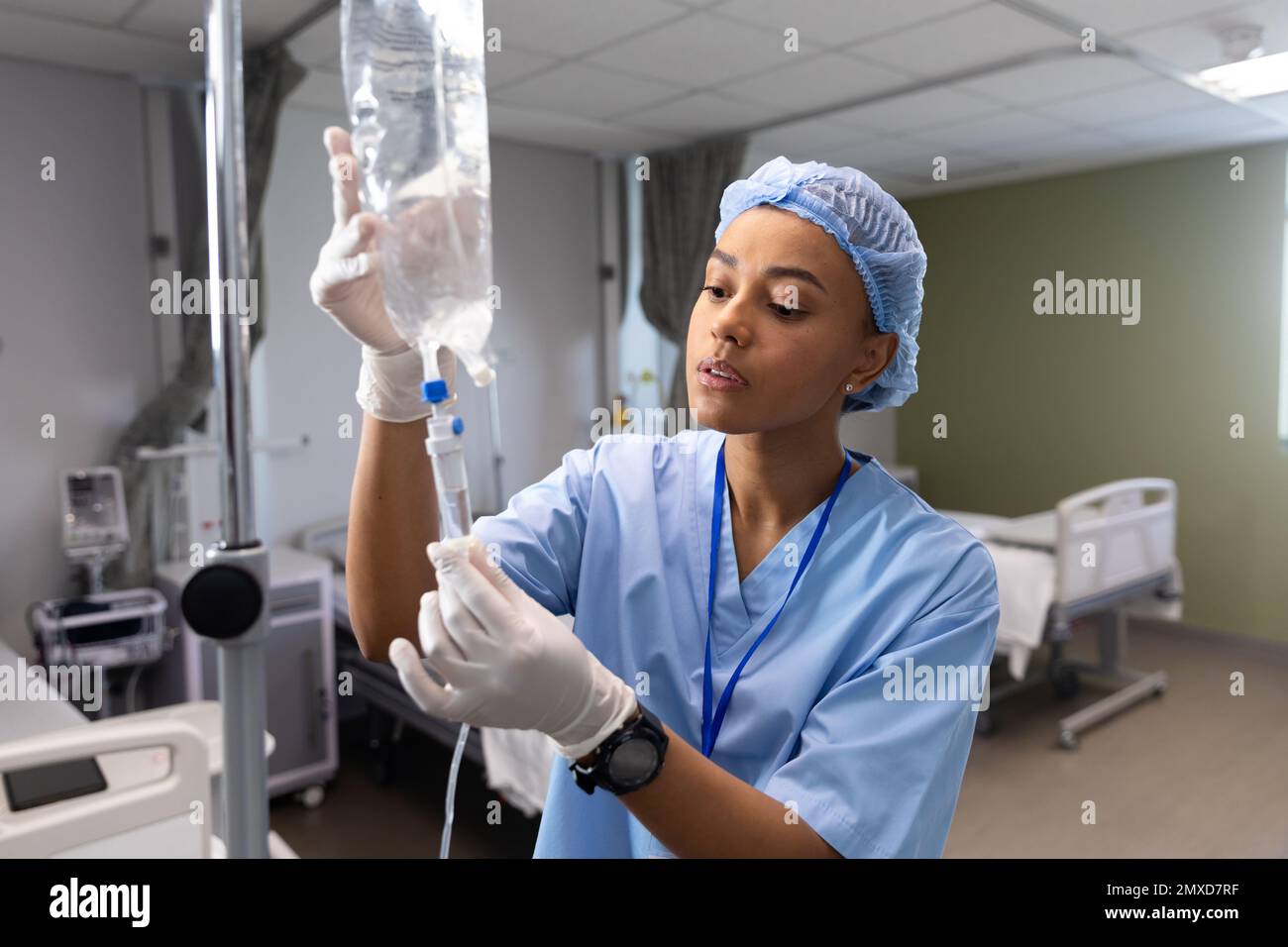 Biracial female doctor working at hospital, changing a drip Stock Photo ...