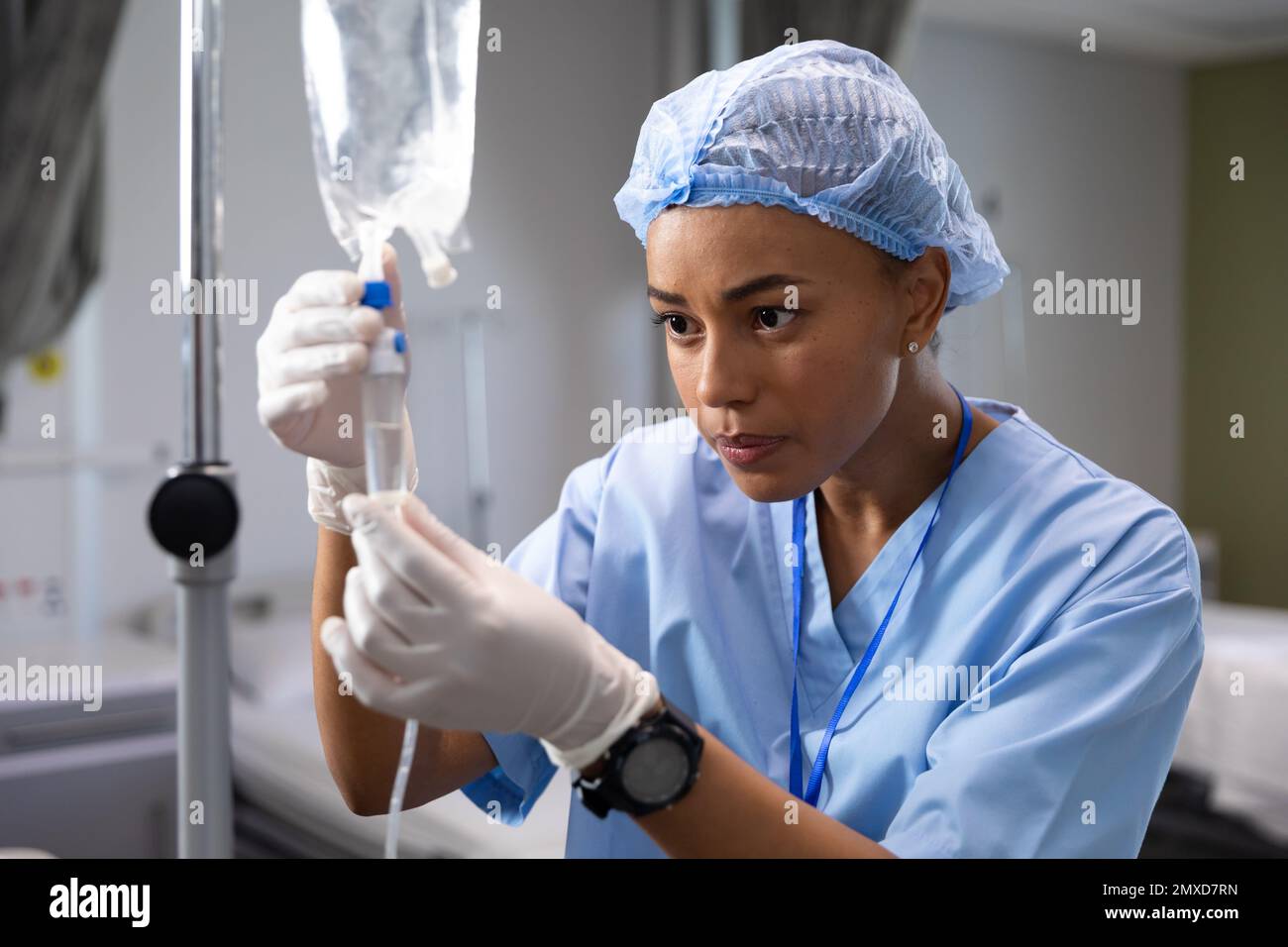 Biracial female doctor working at hospital, changing a drip Stock Photo ...