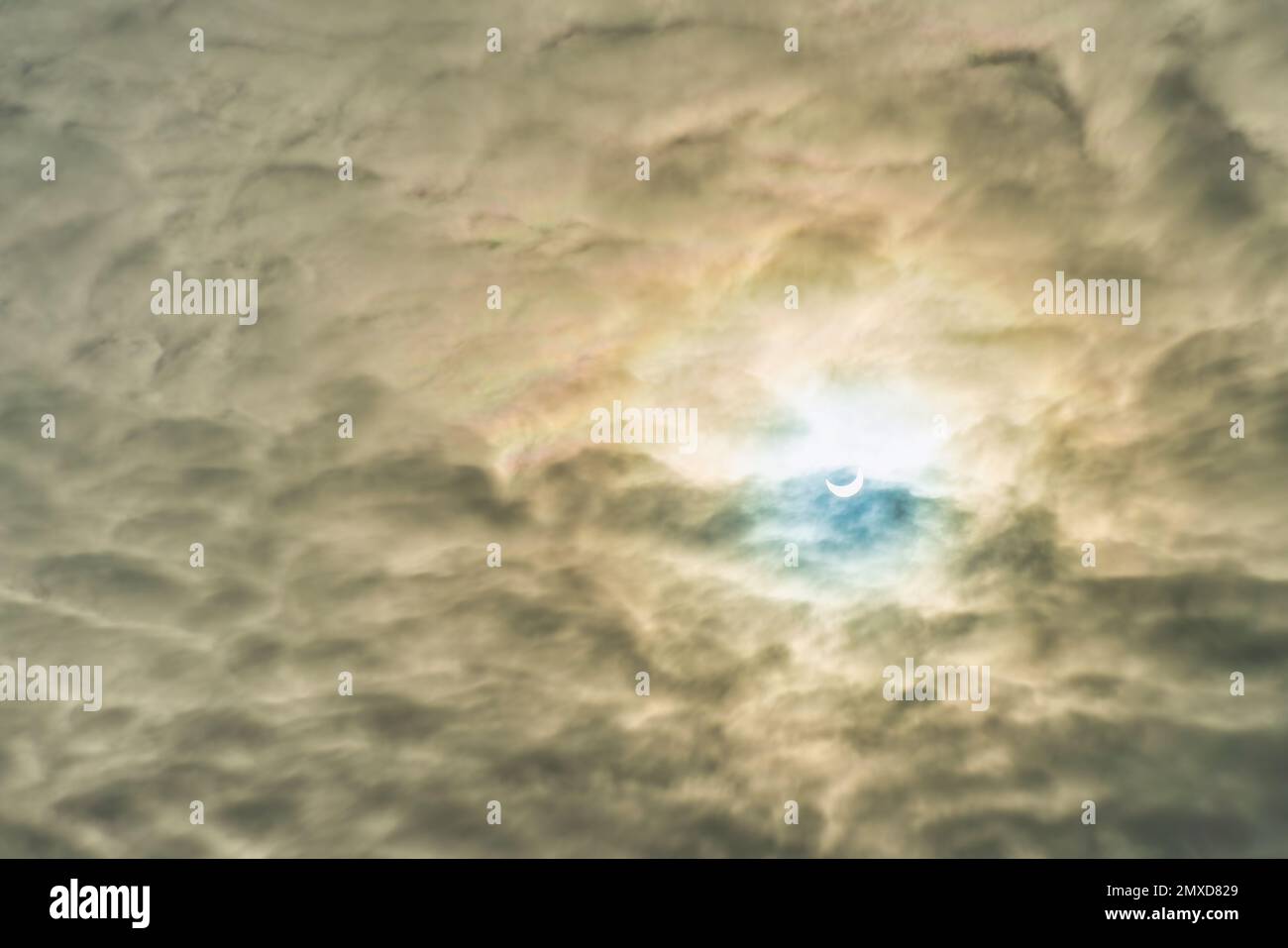 Partial solar eclipse passing behind dramatic clouds Stock Photo - Alamy
