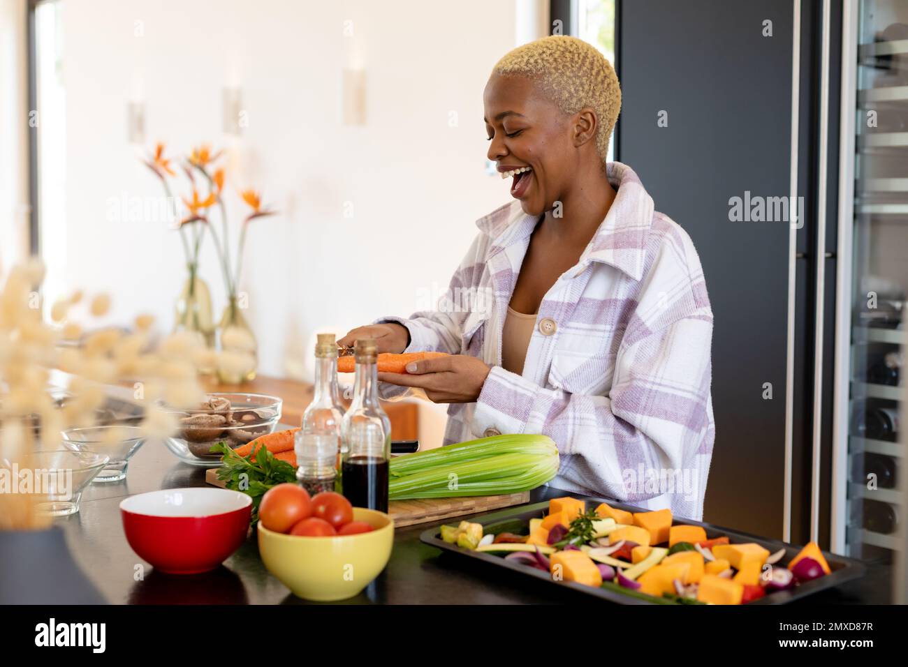 Happy african american woman cooking in kitchen, chopping vegetables ...