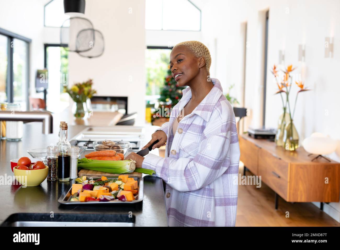Happy african american woman cooking in kitchen, chopping vegetables ...