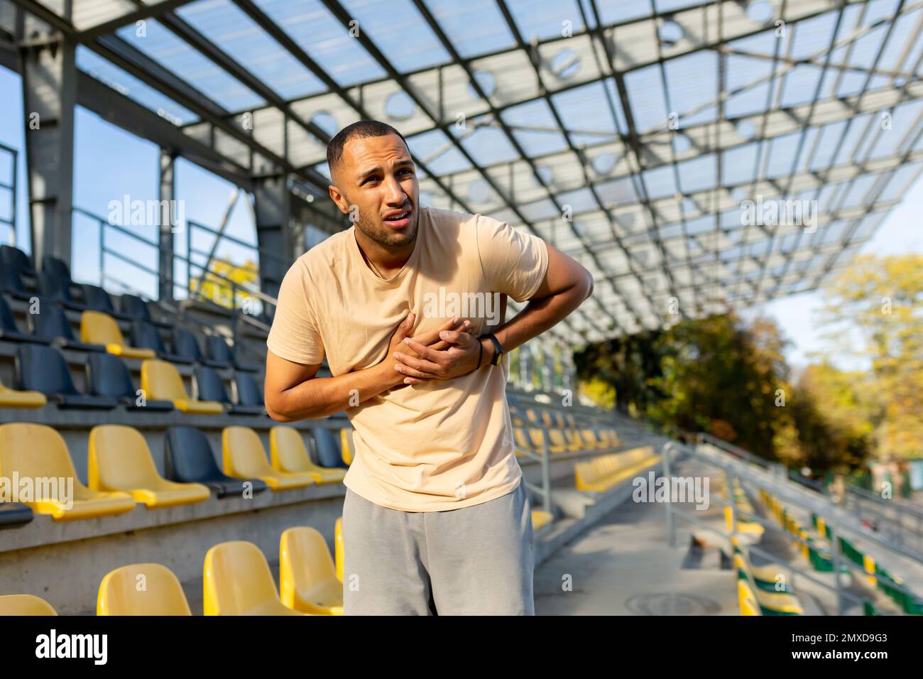 Sick athlete after jogging and vigorous exercise has severe chest pain ...