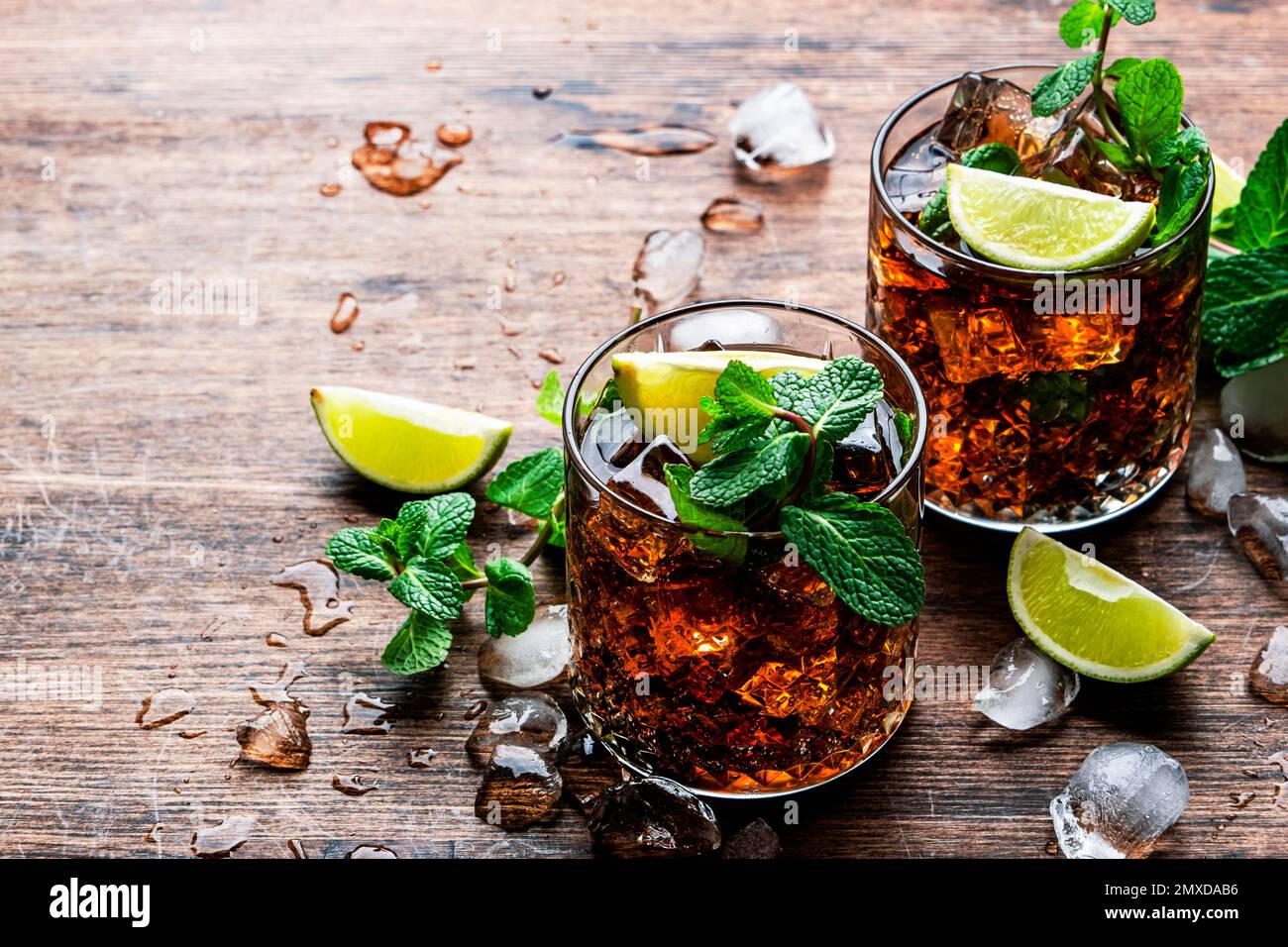 Rum cola cocktail with strong alcohol and ice, garnished with mint and ...