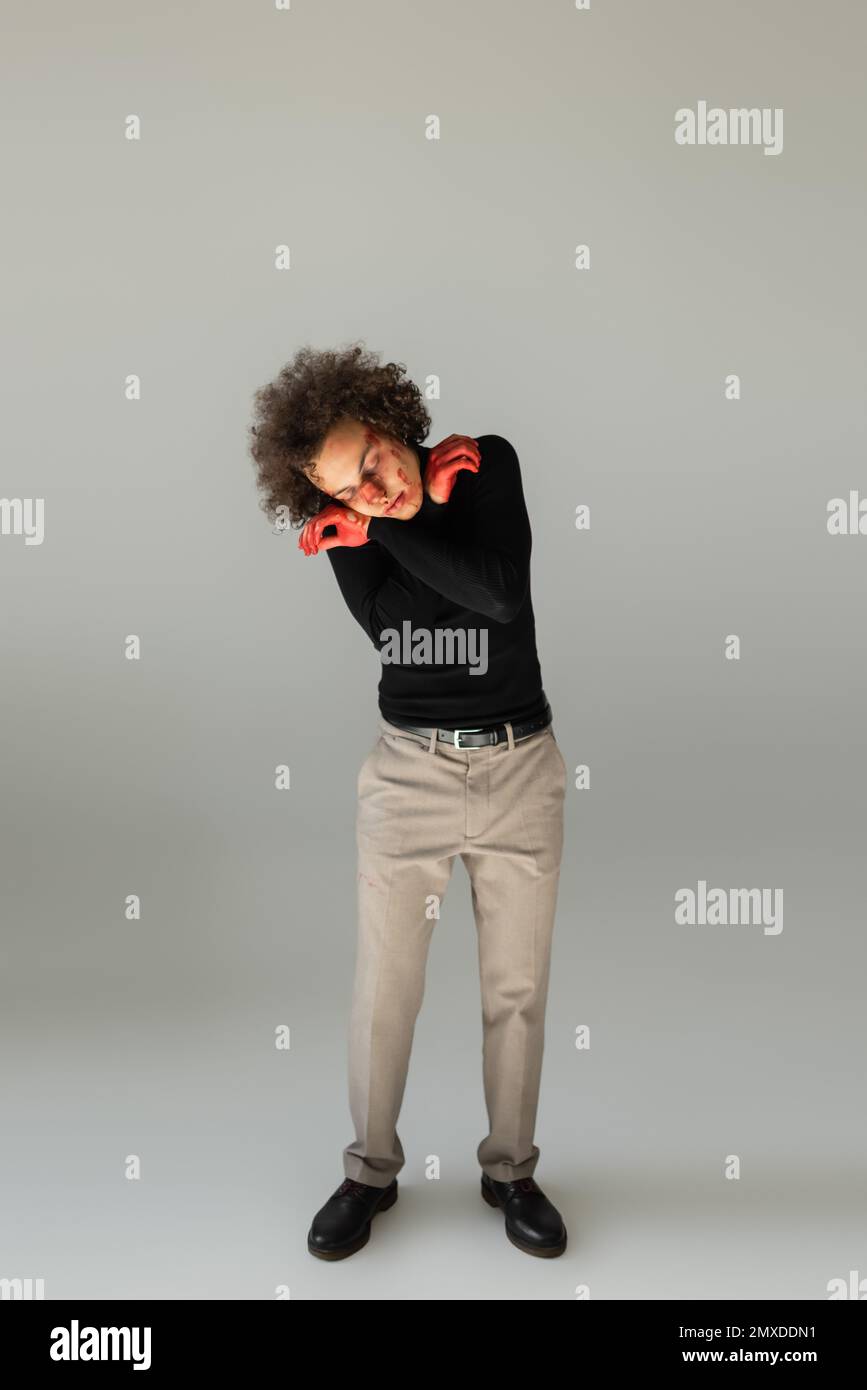 full length of wounded african american man with bleeding face and ...