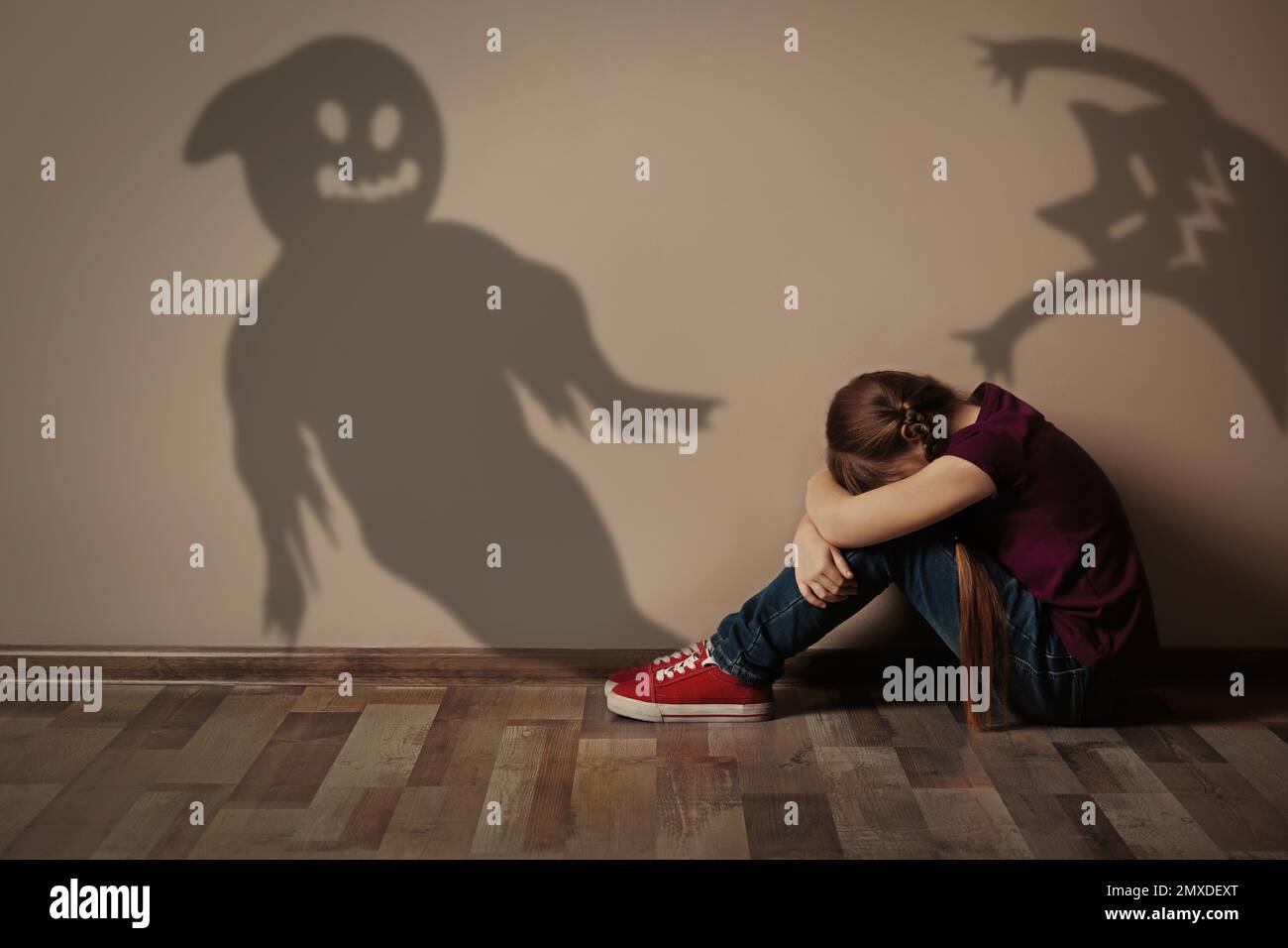 Scared little girl suffering from sciophobia and phantoms behind her ...