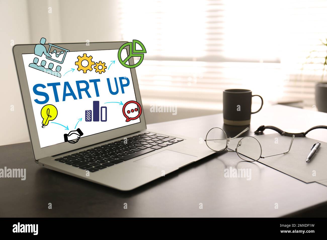 Modern laptop with word STARTUP and different icons on office table Stock Photo - Alamy