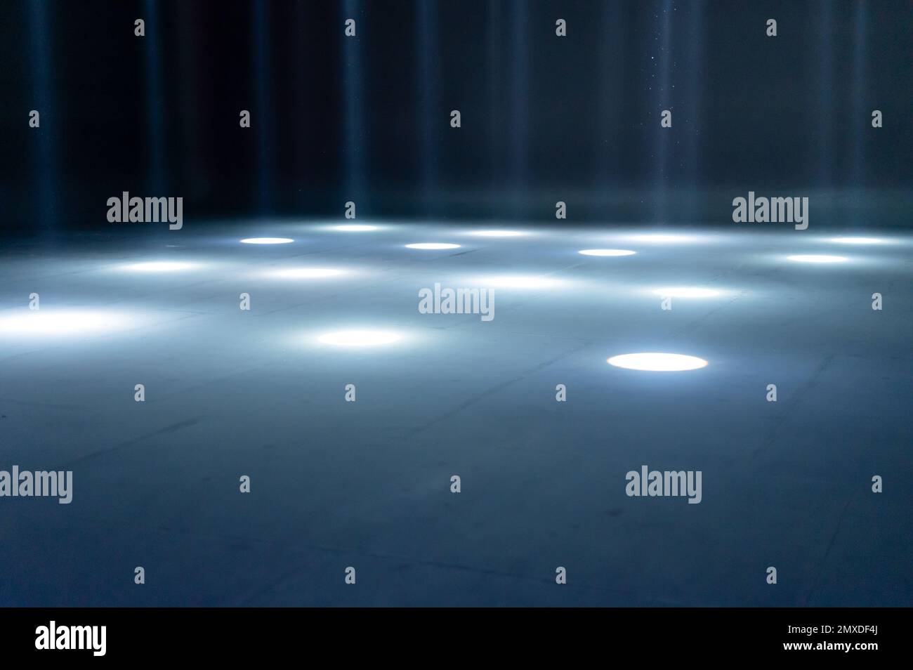 blurred rays of light on disco floor. white blue neon searchlight ...