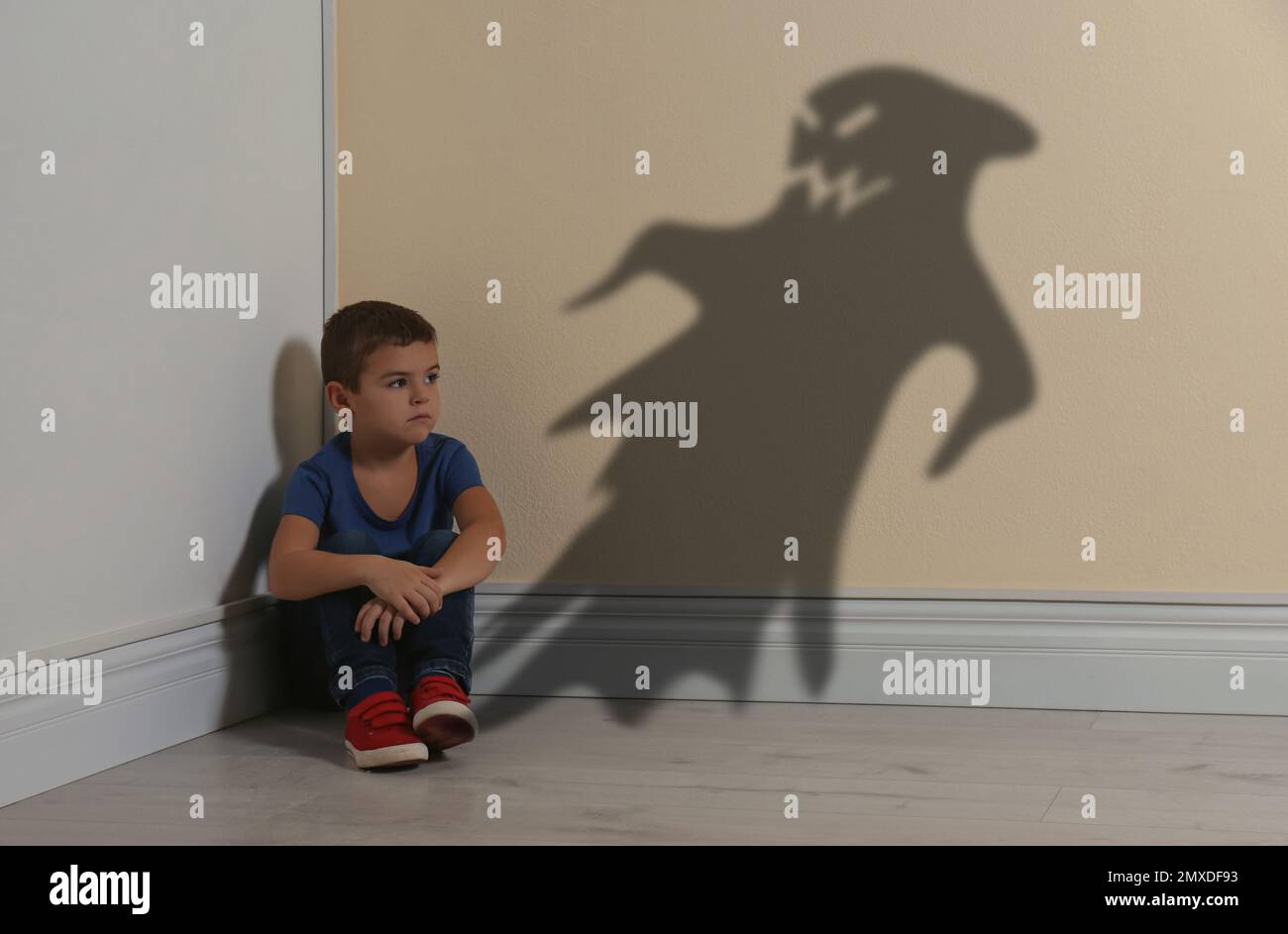 Scared little boy suffering from sciophobia and phantom behind him ...