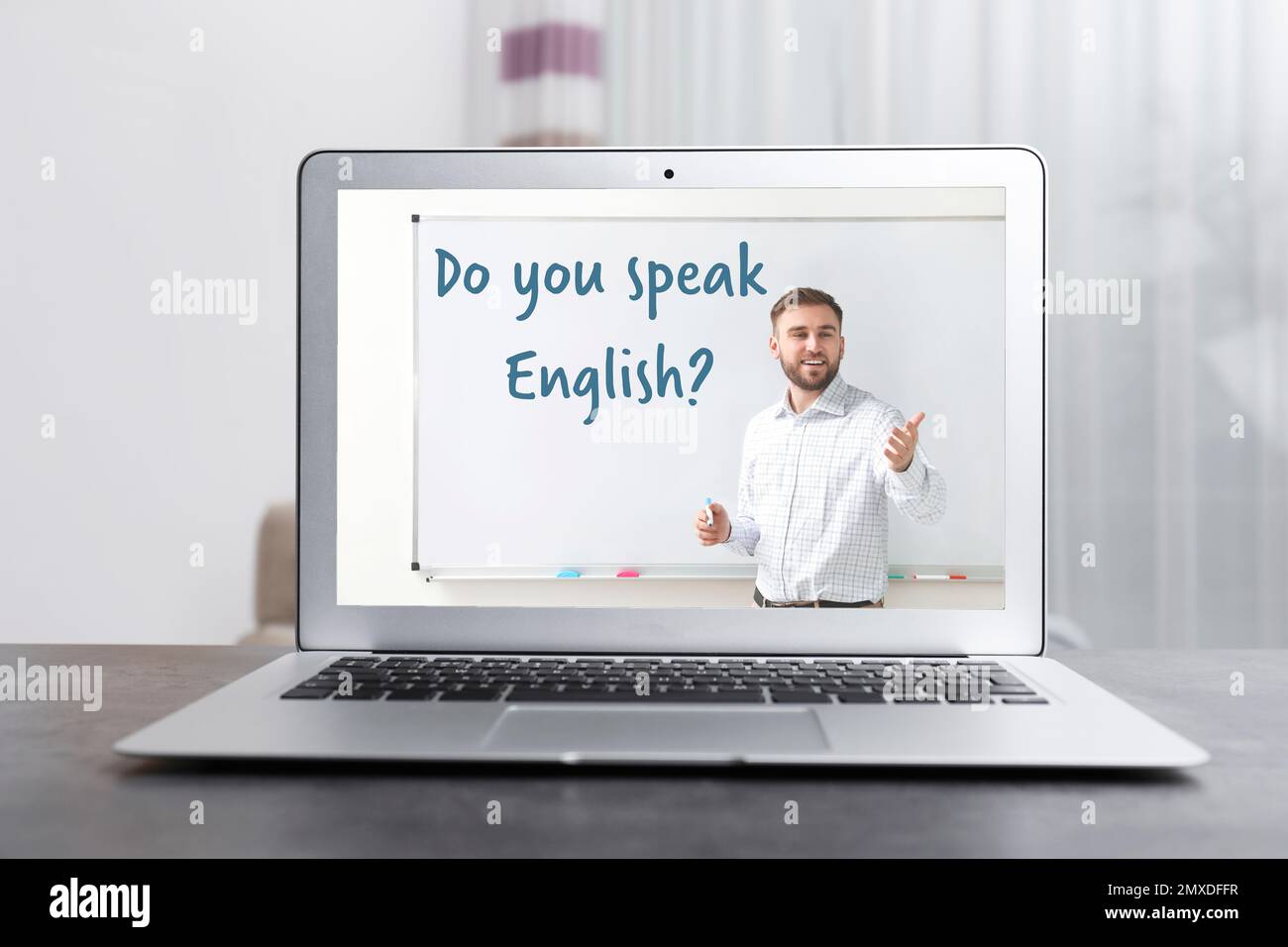 Modern laptop for online English learning with teacher on table indoors ...