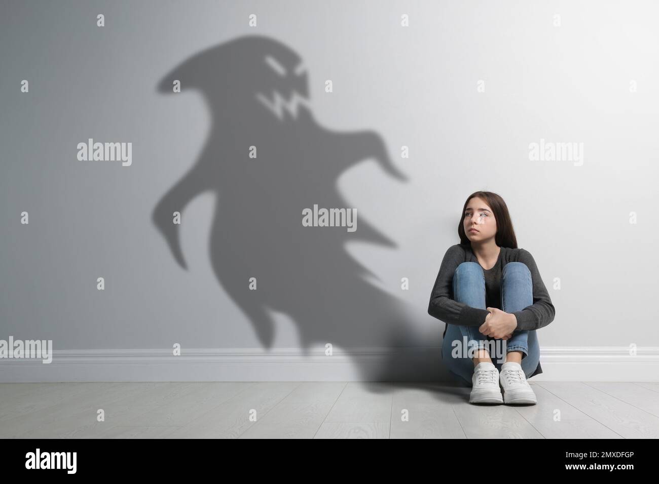 Upset teenage girl suffering from sciophobia and phantom behind her ...