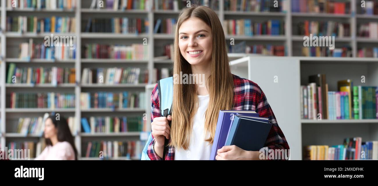 Young pretty student with books and backpack in library, space for text ...