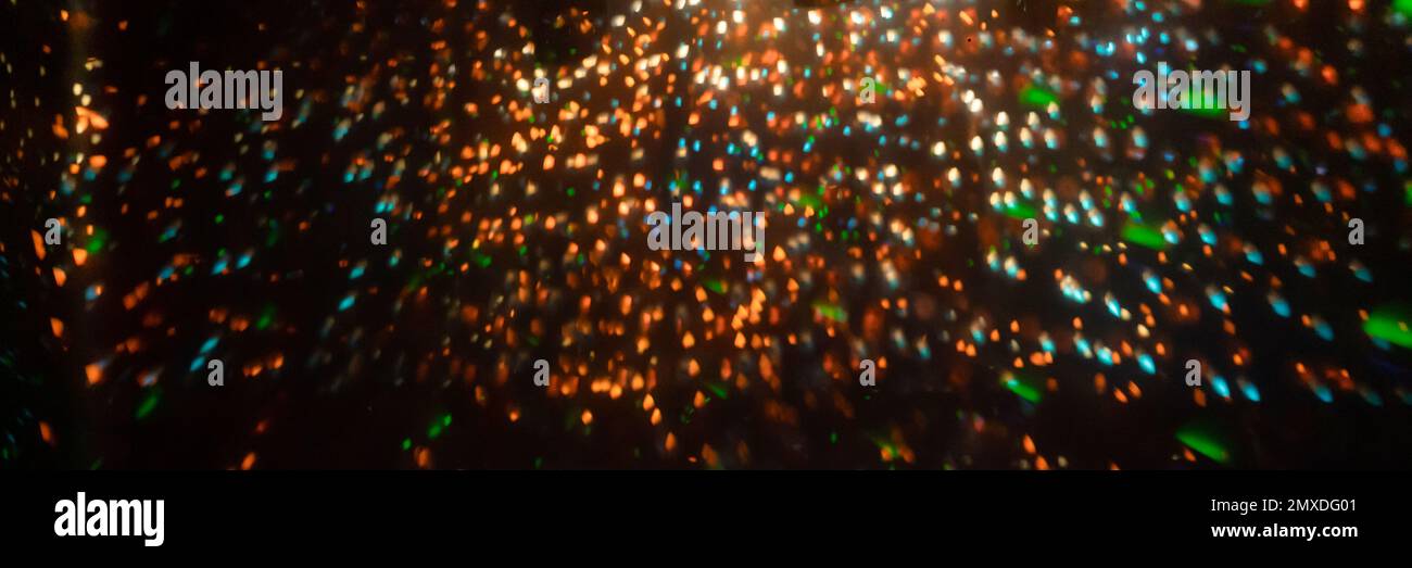 blurred rays of light on disco floor. orange green blue neon ...