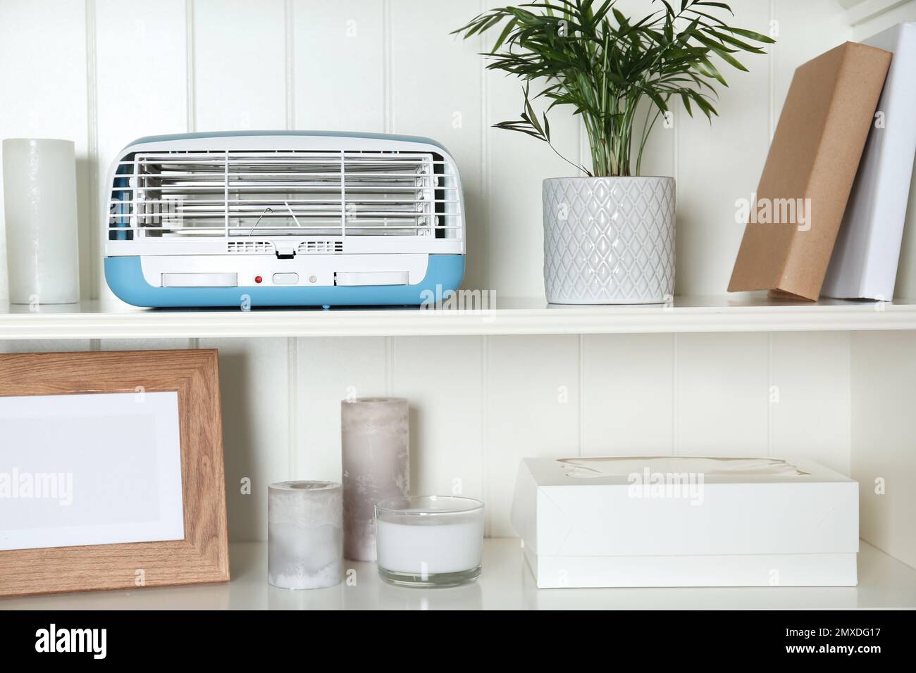 Modern air purifier and different items on white wooden shelves Stock ...