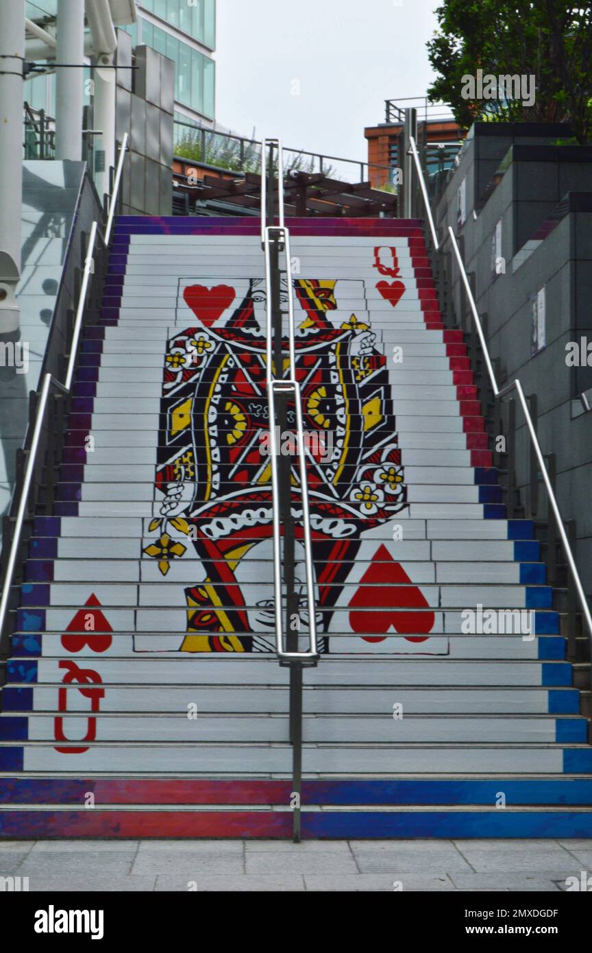 A vertical shot of a city staircase painted in a queen of hearts card ...