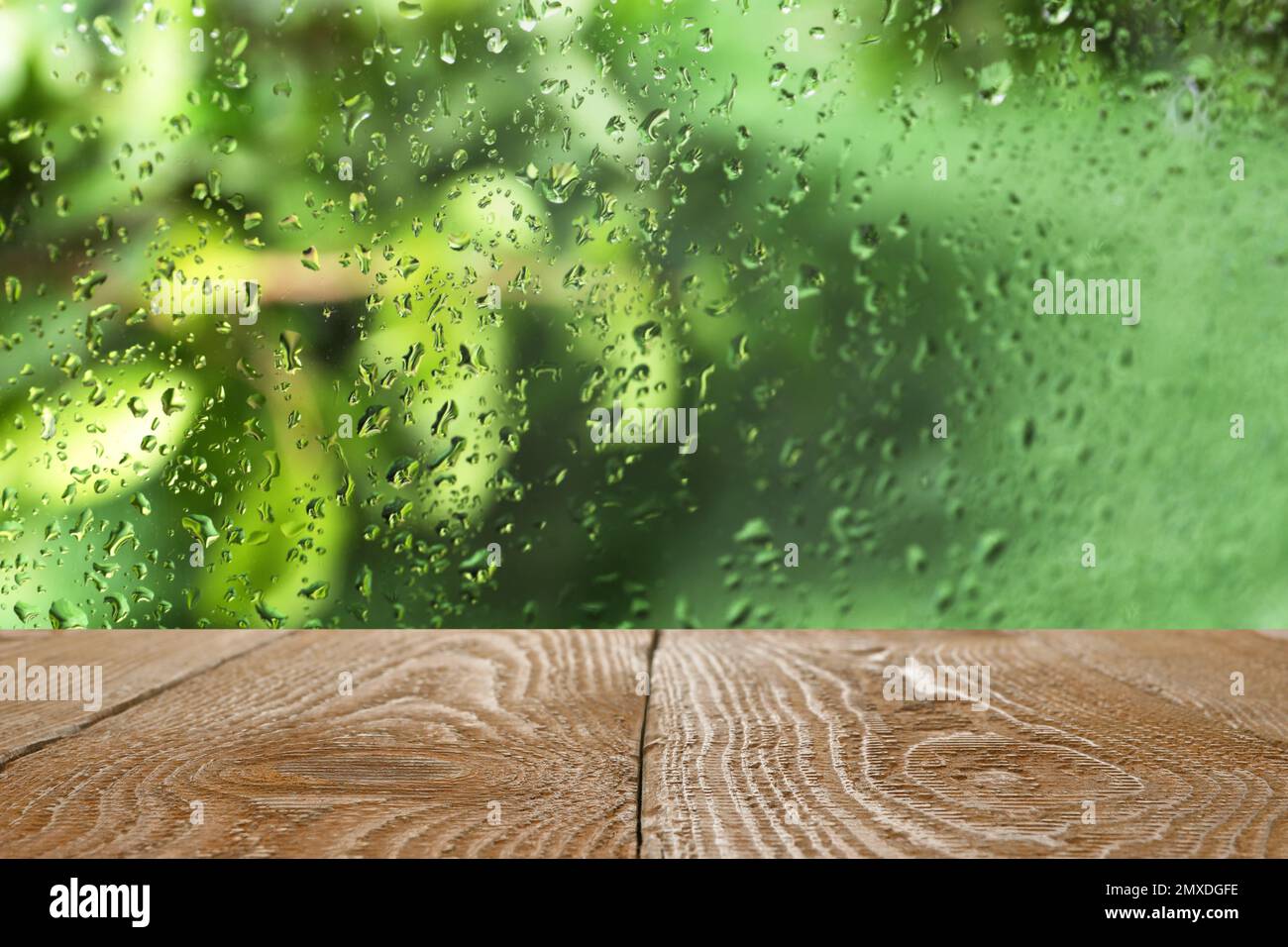 Wooden table near window on rainy day Stock Photo - Alamy