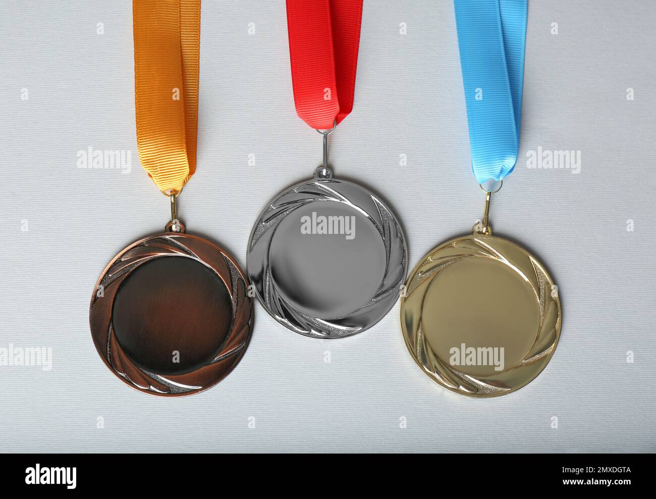 Gold, silver and bronze medals on white background, flat lay. Space for ...