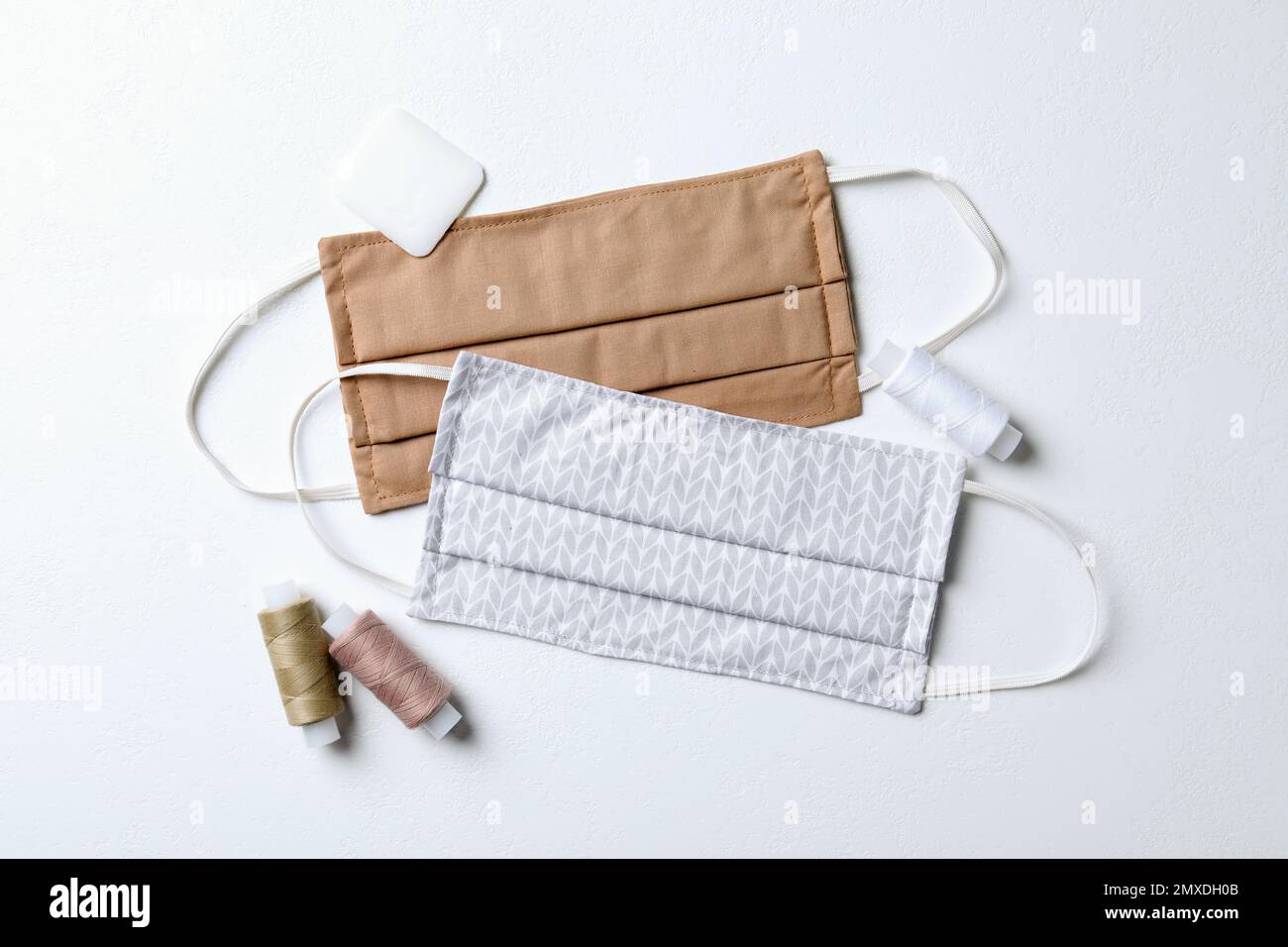 Homemade protective masks, threads and tailor's chalk on white ...
