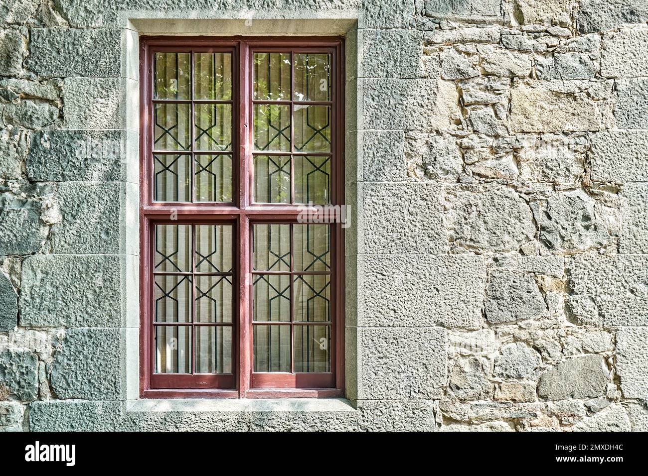 Old windows with wrought iron grating on stone wall of historical ...