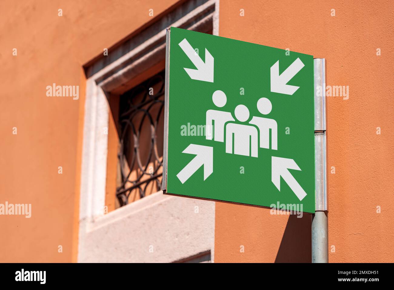 Emergency assembly point. Closeup of a green sign in a city against a ...