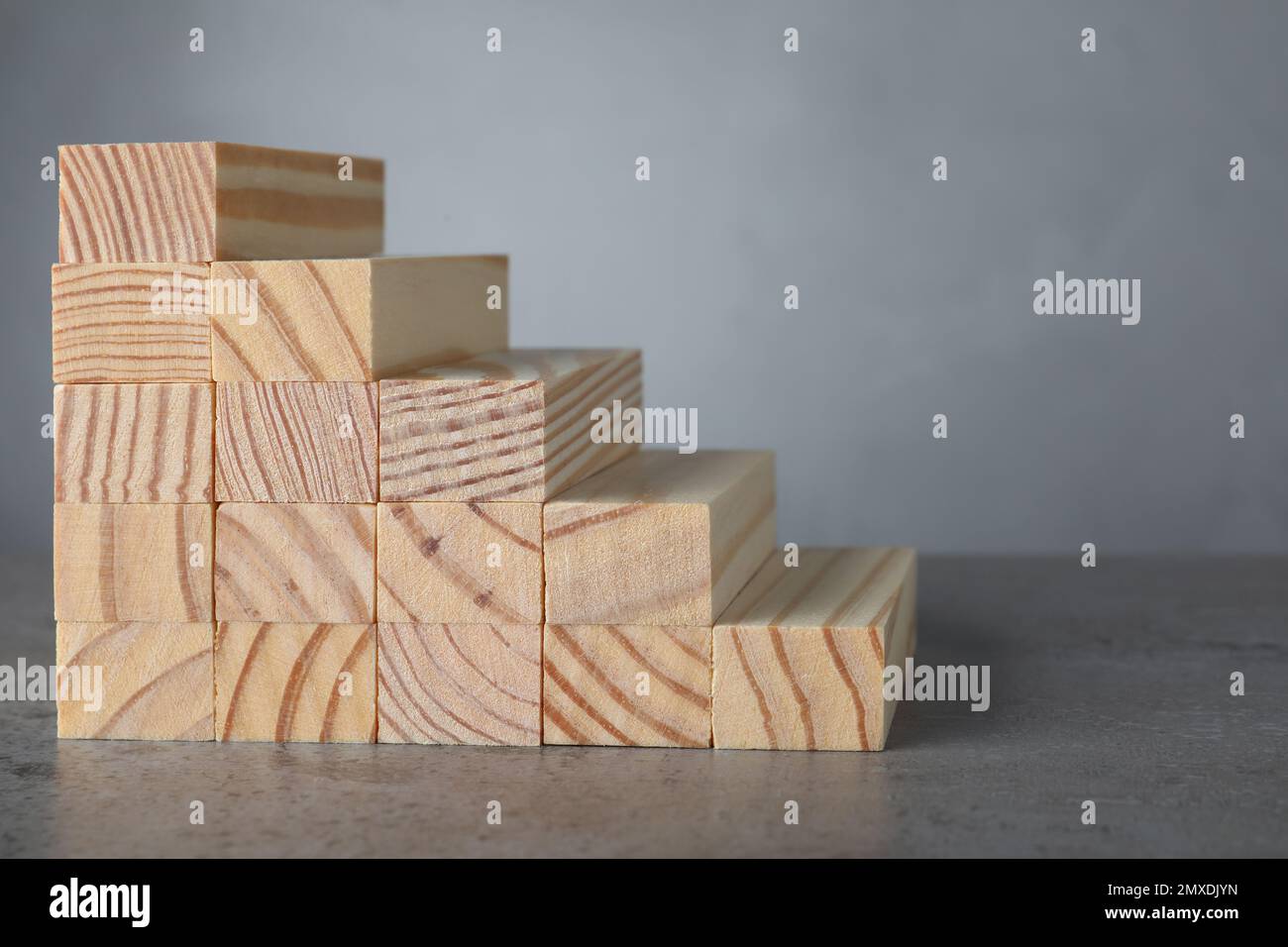 Steps made with wooden blocks on table against grey background, space ...