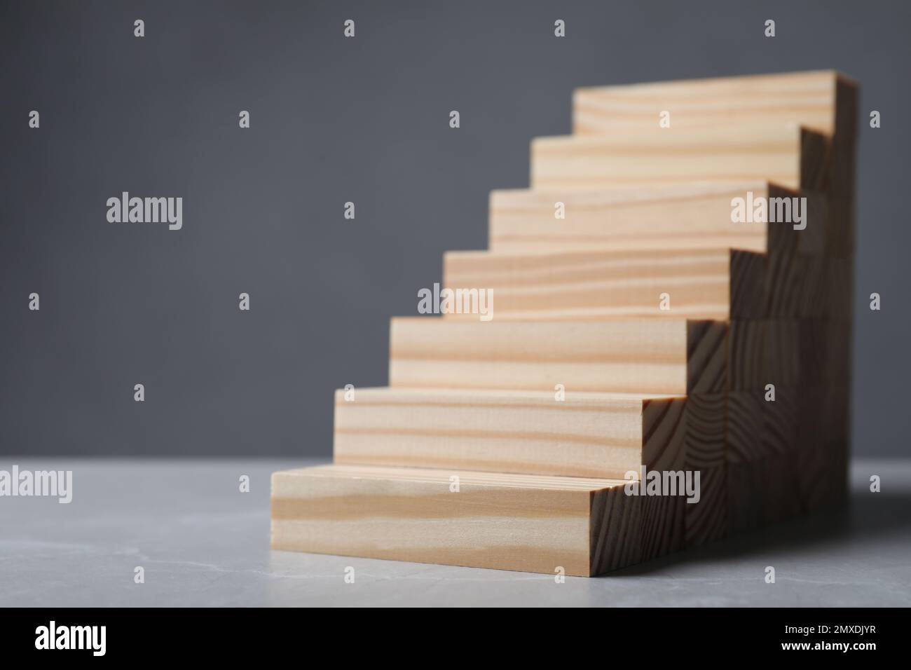 Steps made with wooden blocks on table against grey background, space ...