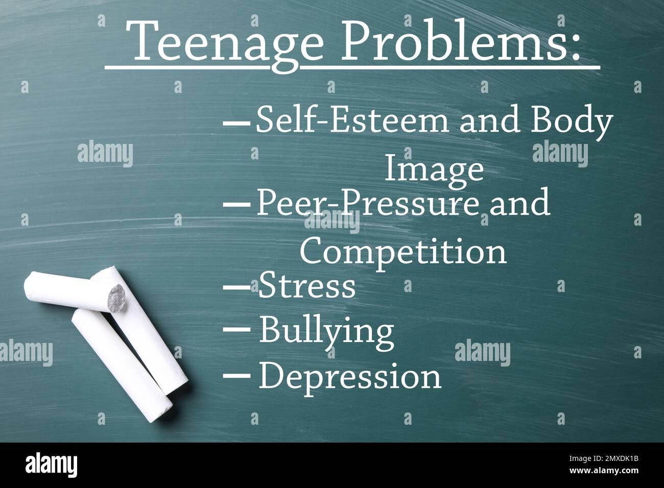 Pieces of chalk and most common teens problems written on greenboard ...