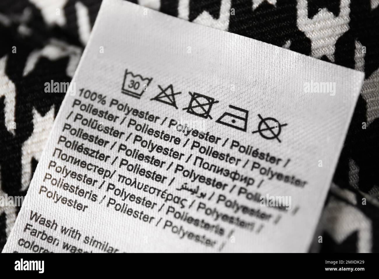 Clothing label with care symbols and material content on shirt, closeup ...