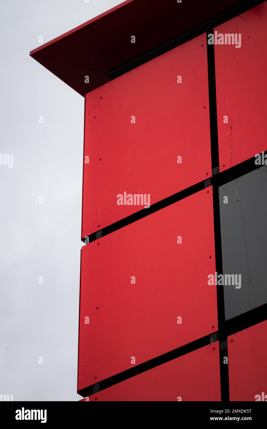 A vertical shot of the angle of the red and black building with square ...