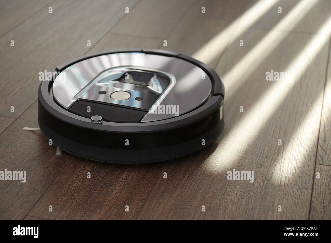 Modern robotic vacuum cleaner on wooden floor Stock Photo - Alamy