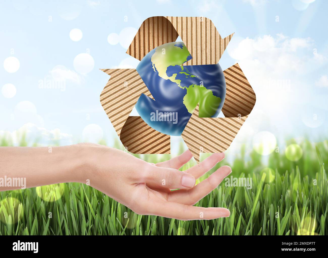 Woman with illustration of Earth and recycling symbol in hand, closeup ...