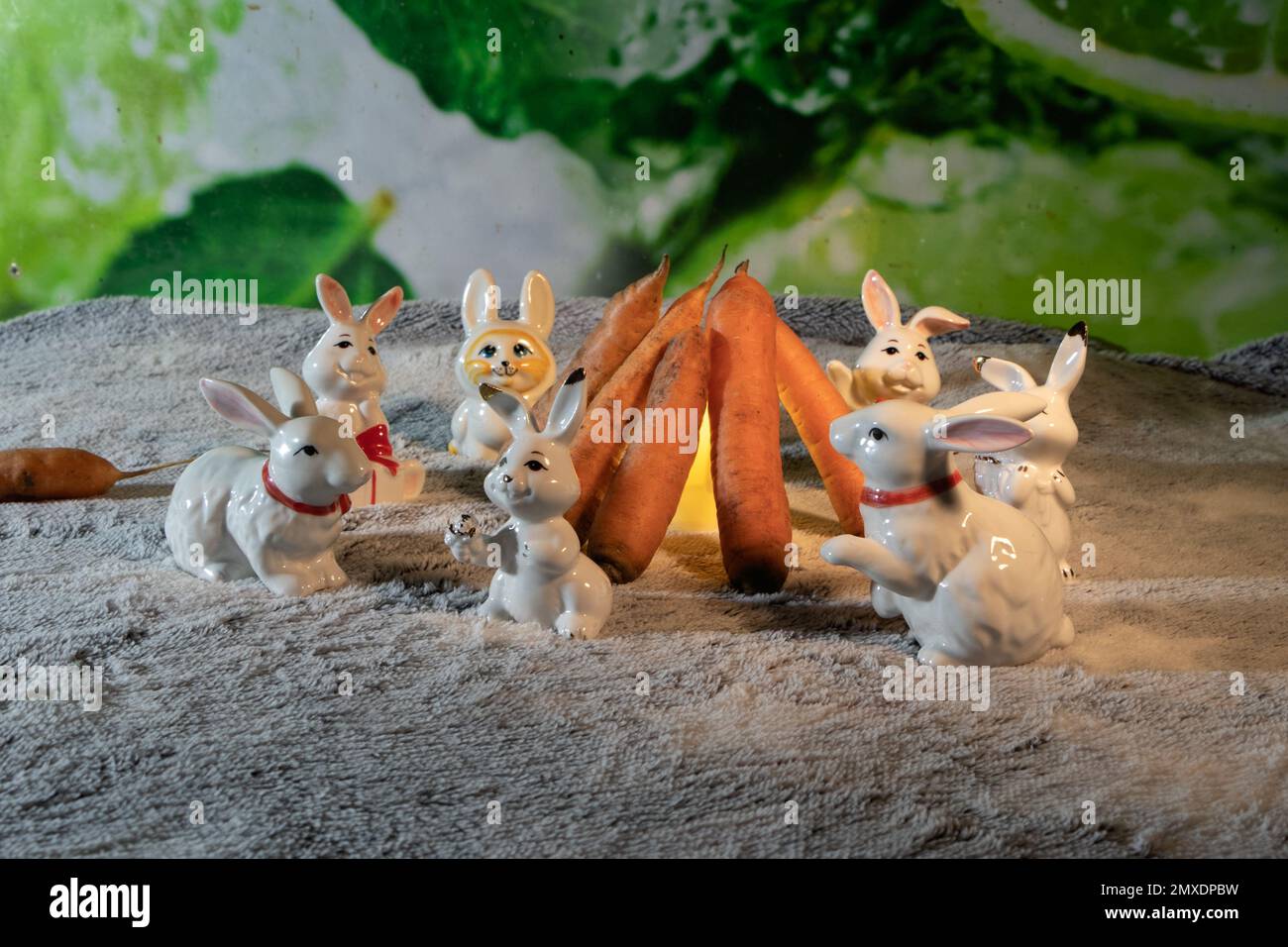 Porcelain figurines of rabbits sit around a fire of carrots. Photo ...