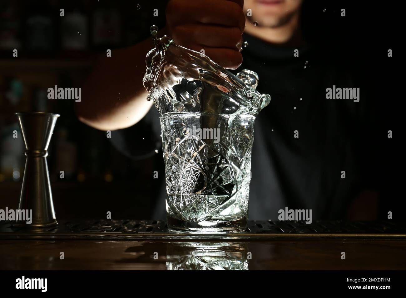 Bartender preparing fresh alcoholic cocktail at bar counter, focus on ...