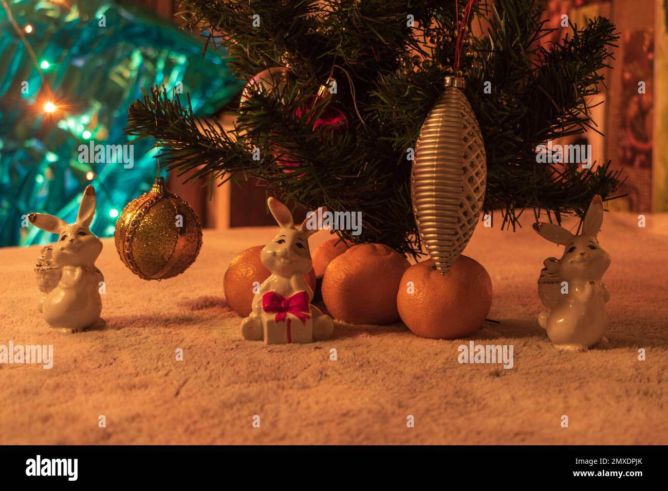 Porcelain Figurines Of Rabbits Sit Under The Christmas Tree The Photo