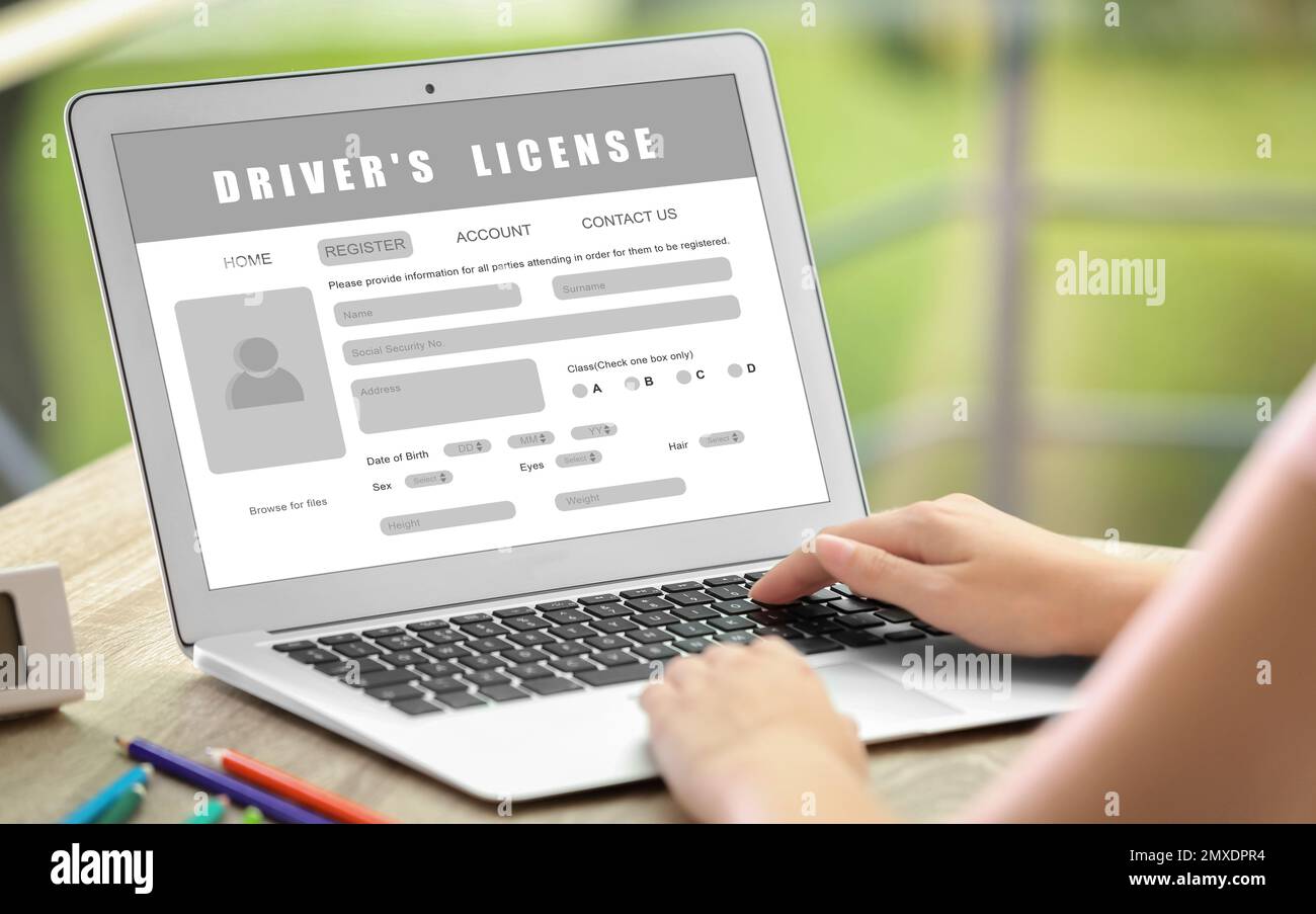 Woman filling in driver's license form online on website using laptop ...