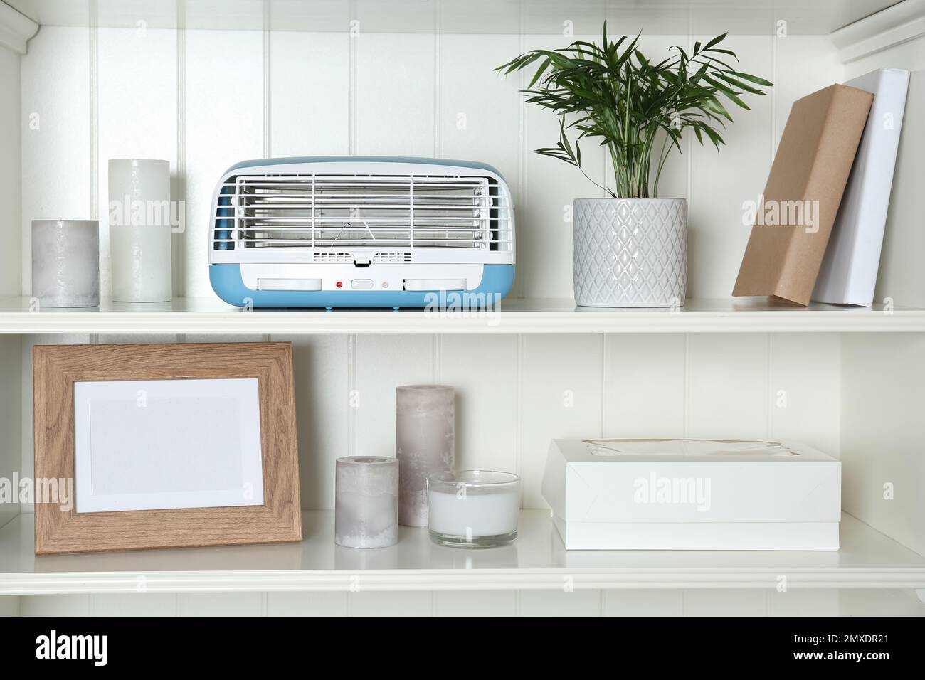 Modern air purifier and different items on white wooden shelves Stock ...