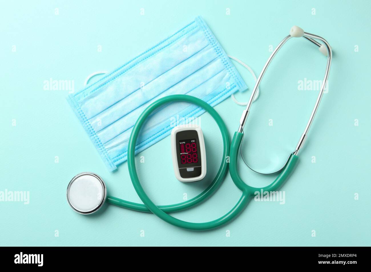 Flat lay composition with modern fingertip pulse oximeter, mask and ...